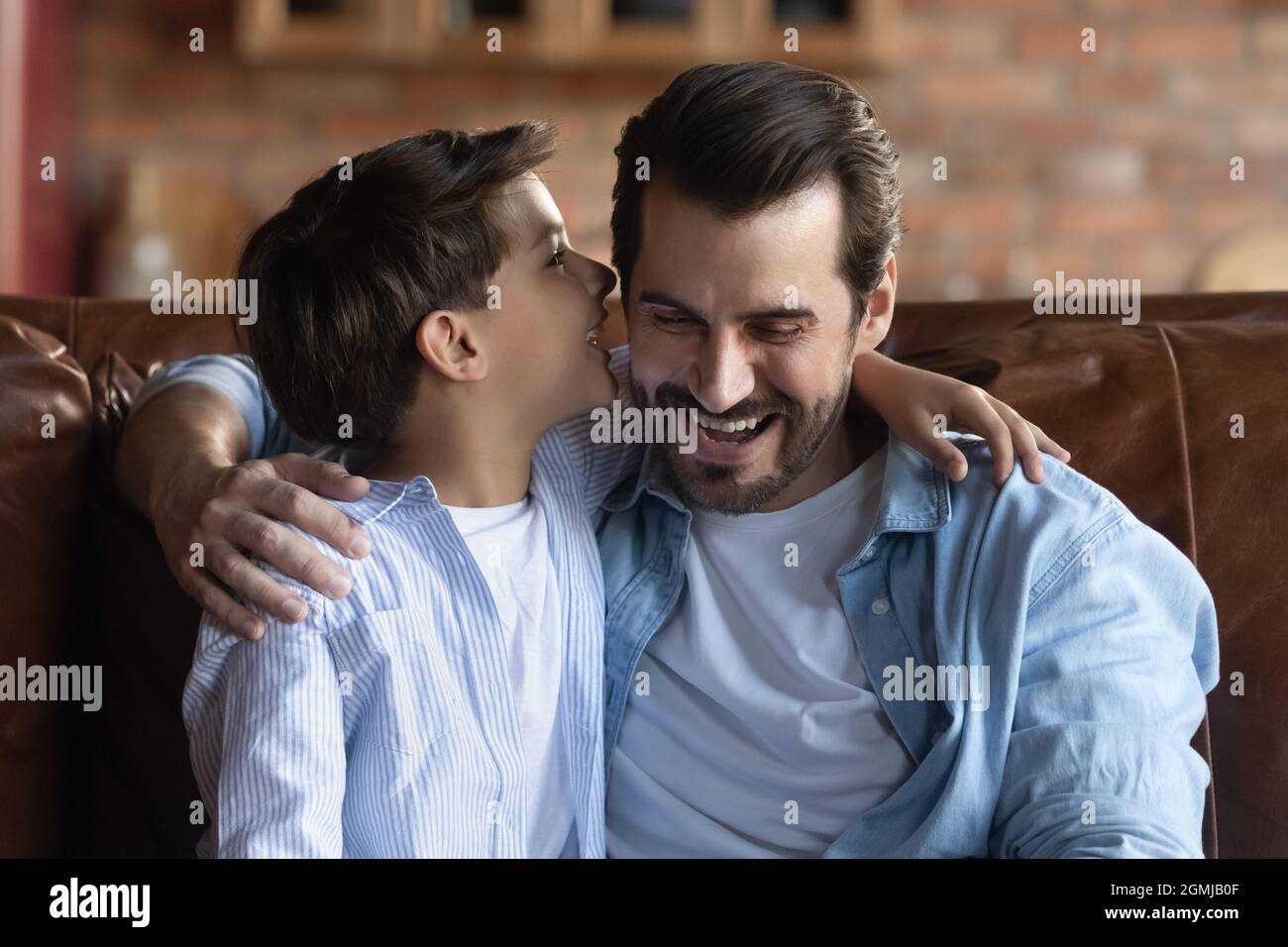 Head shot little boy whispering into father ear, having fun Stock Photo ...