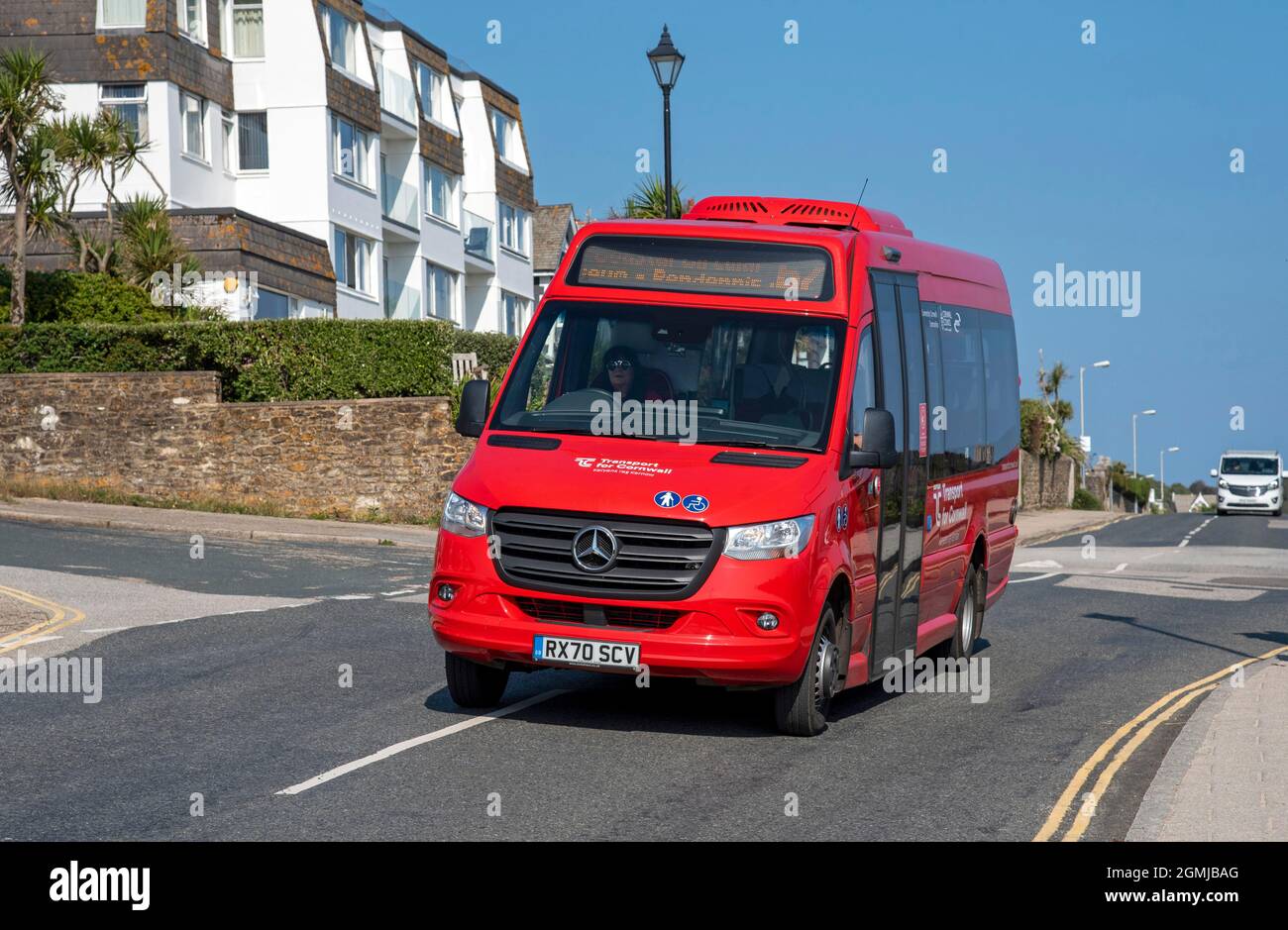 Mousehole southwest Cornwall, UK. 2021, Small red bus entering ...