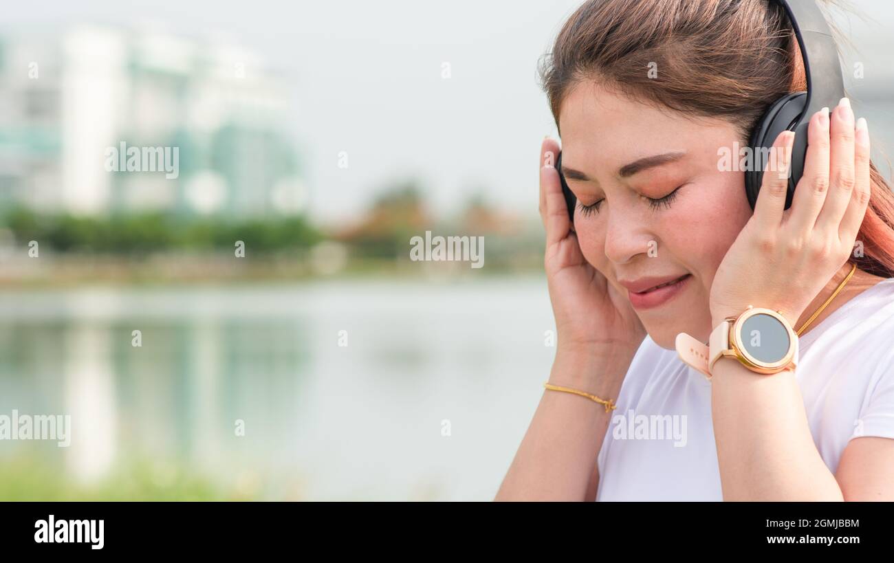 Asian women Happy listening music outdoor Stock Photo - Alamy
