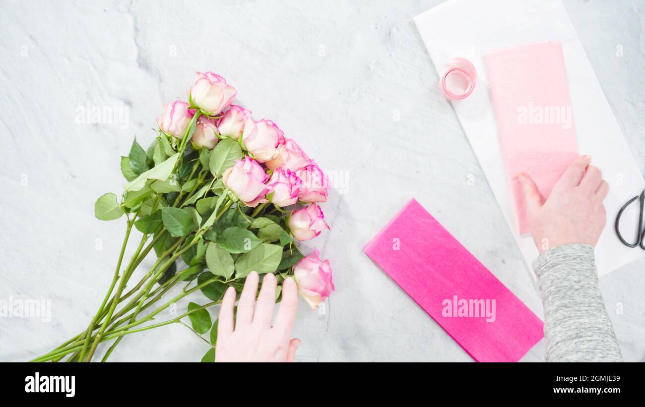 Flat lay. Step by step. Florist arranging a bouquet from pink roses ...