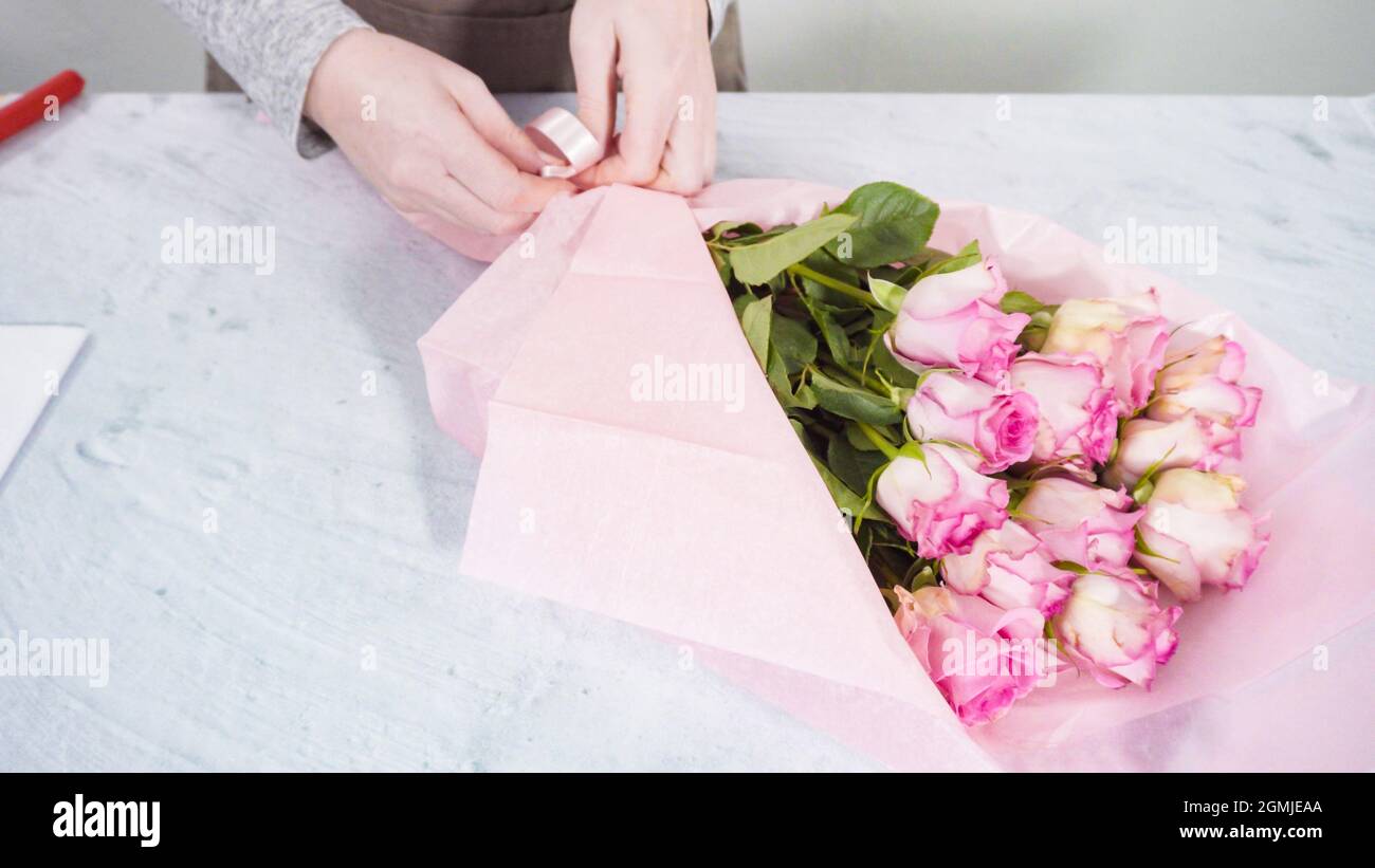 Step by step. Florist arranging a bouquet from pink roses Stock Photo ...