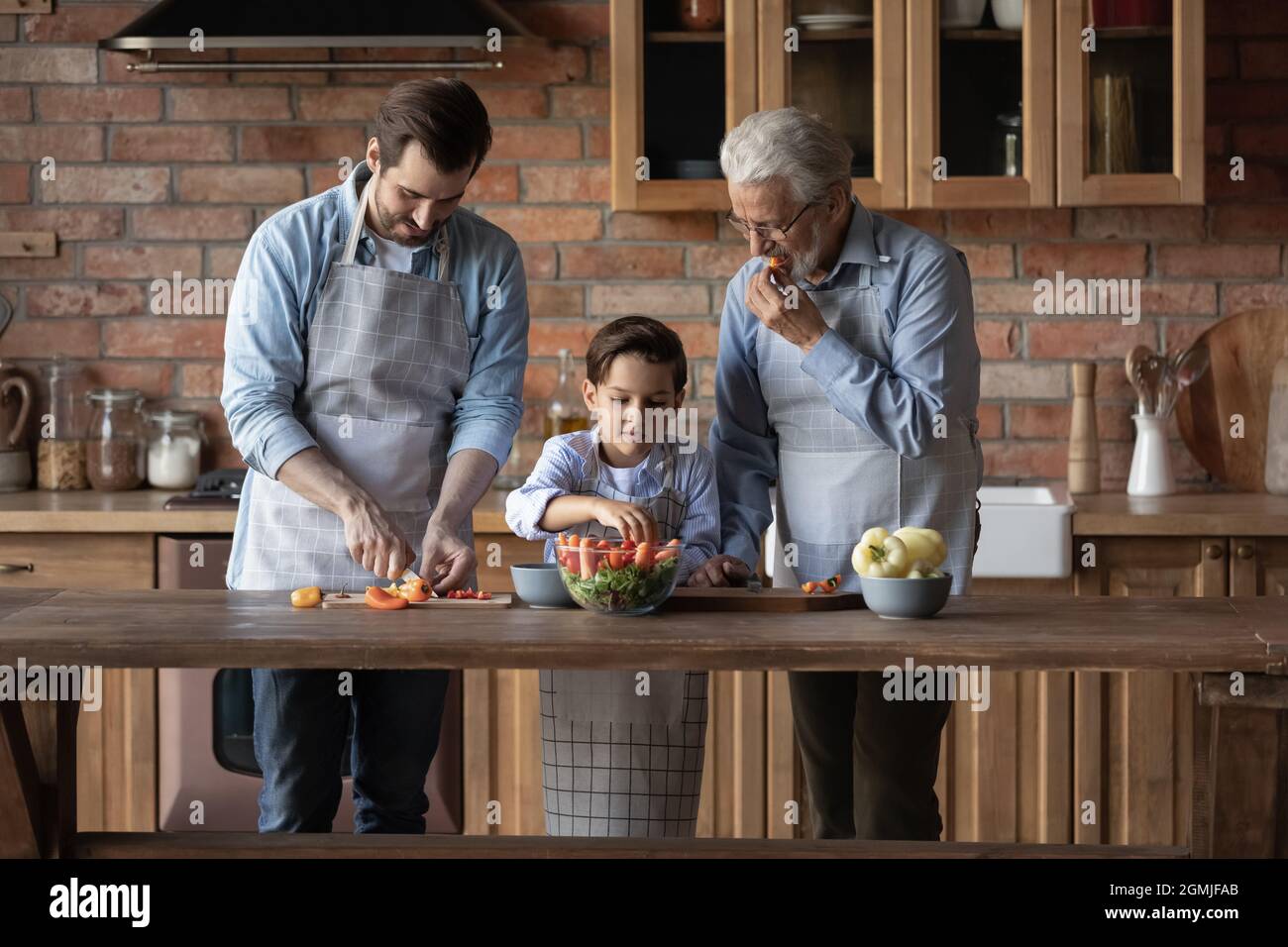 Happy three generations of men cooking in kitchen together Stock Photo ...