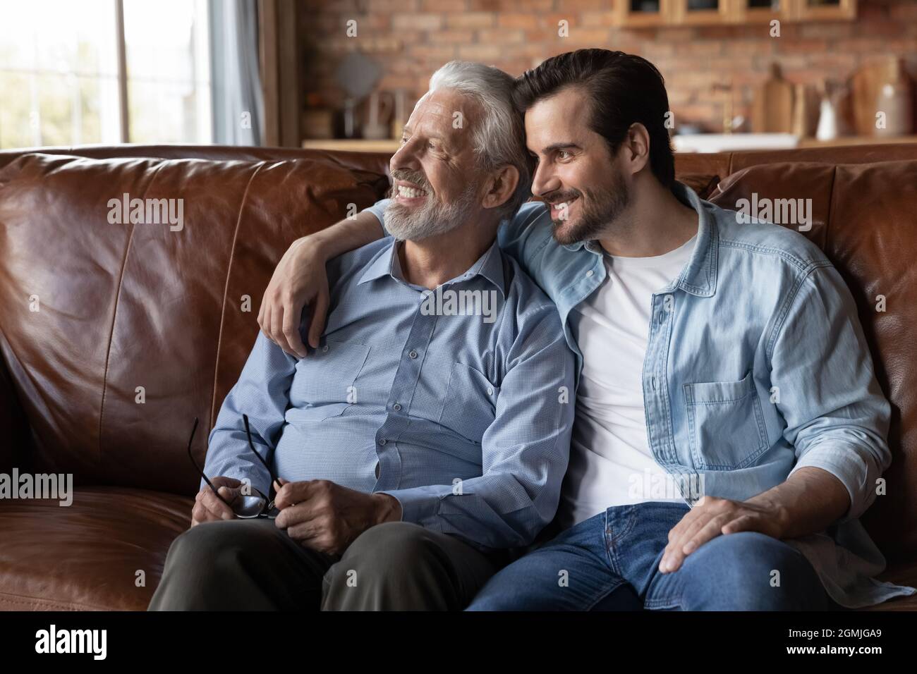 Happy dreamy two generations of men looking in distance Stock Photo - Alamy