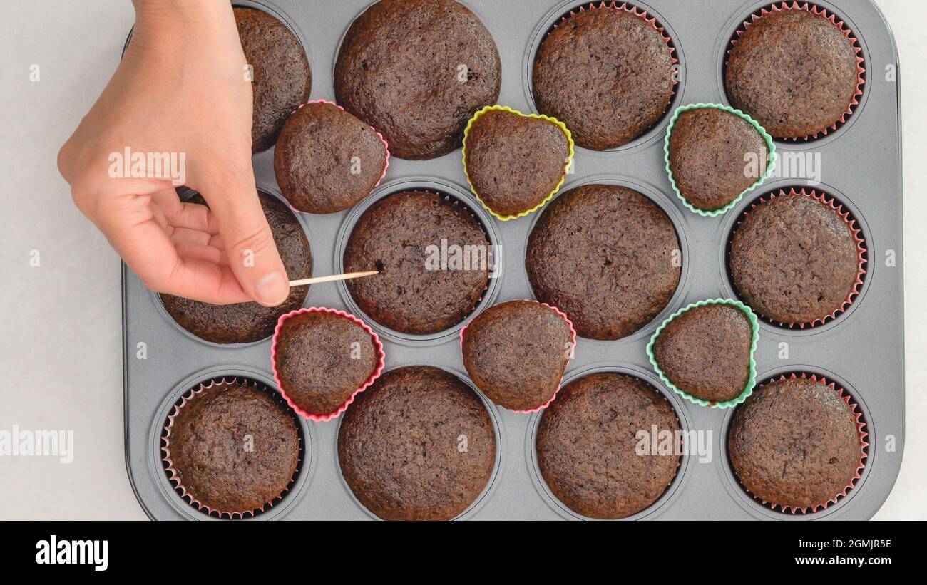 Chocolate cupcakes close up on baking pan. Chef checking cupcakes for ...