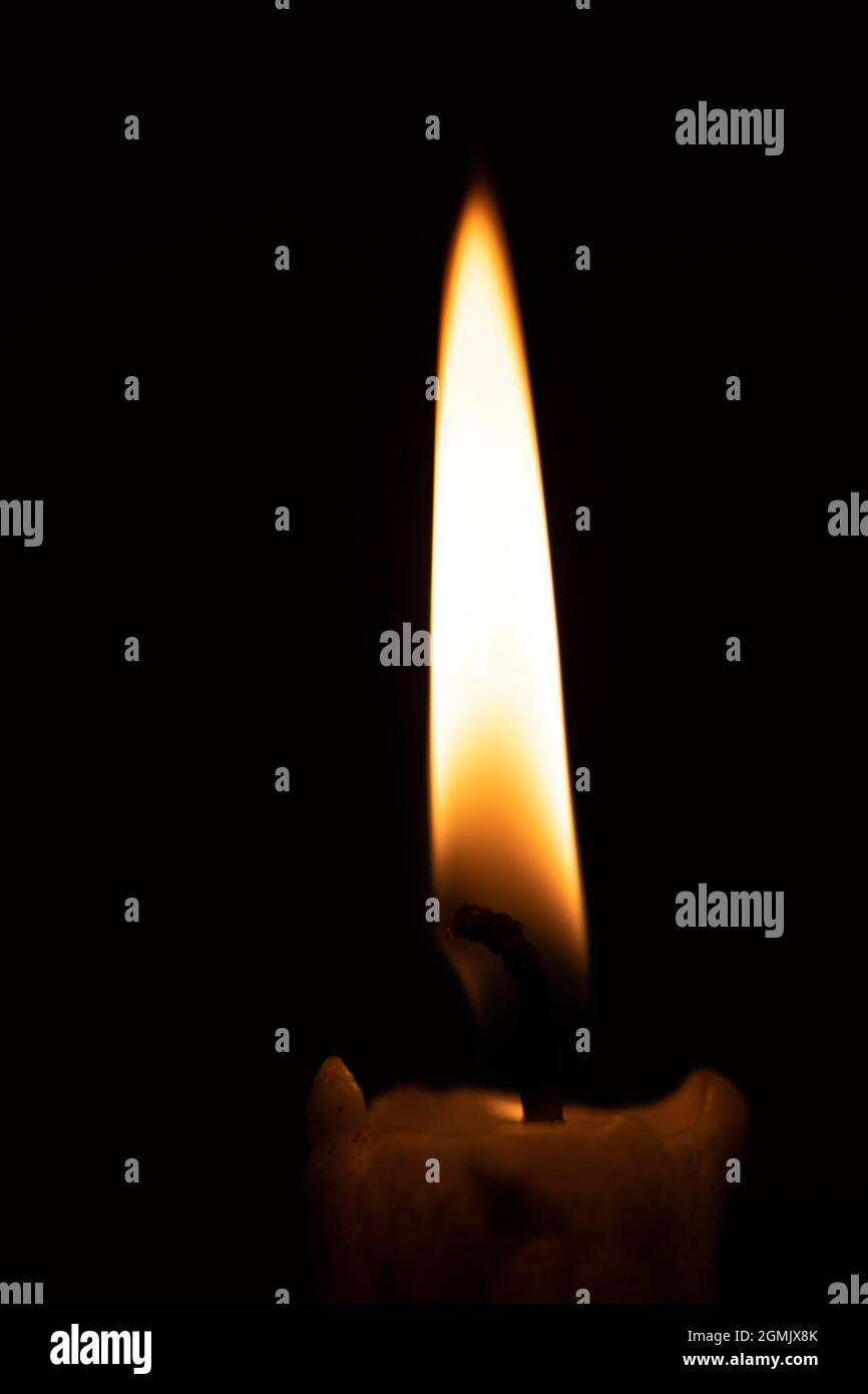 Candle flame in the dark. Fire against a dark background, symbolism of ...