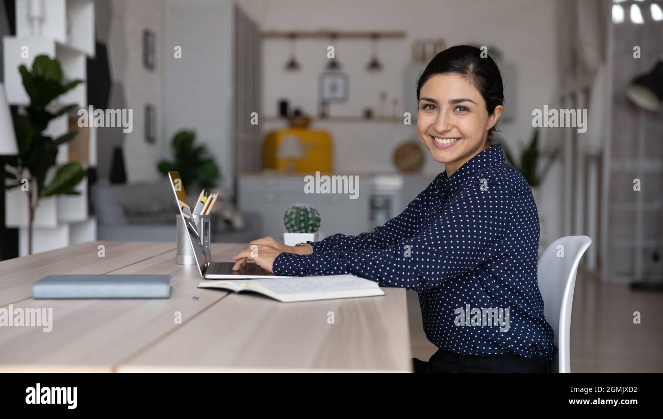 Portrait smiling Indian businesswoman using laptop at workplace Stock ...