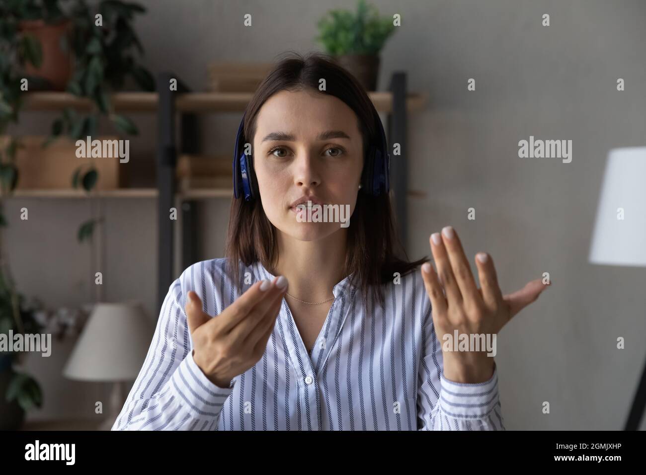 Head shot portrait woman in headphones speaking, making video call ...