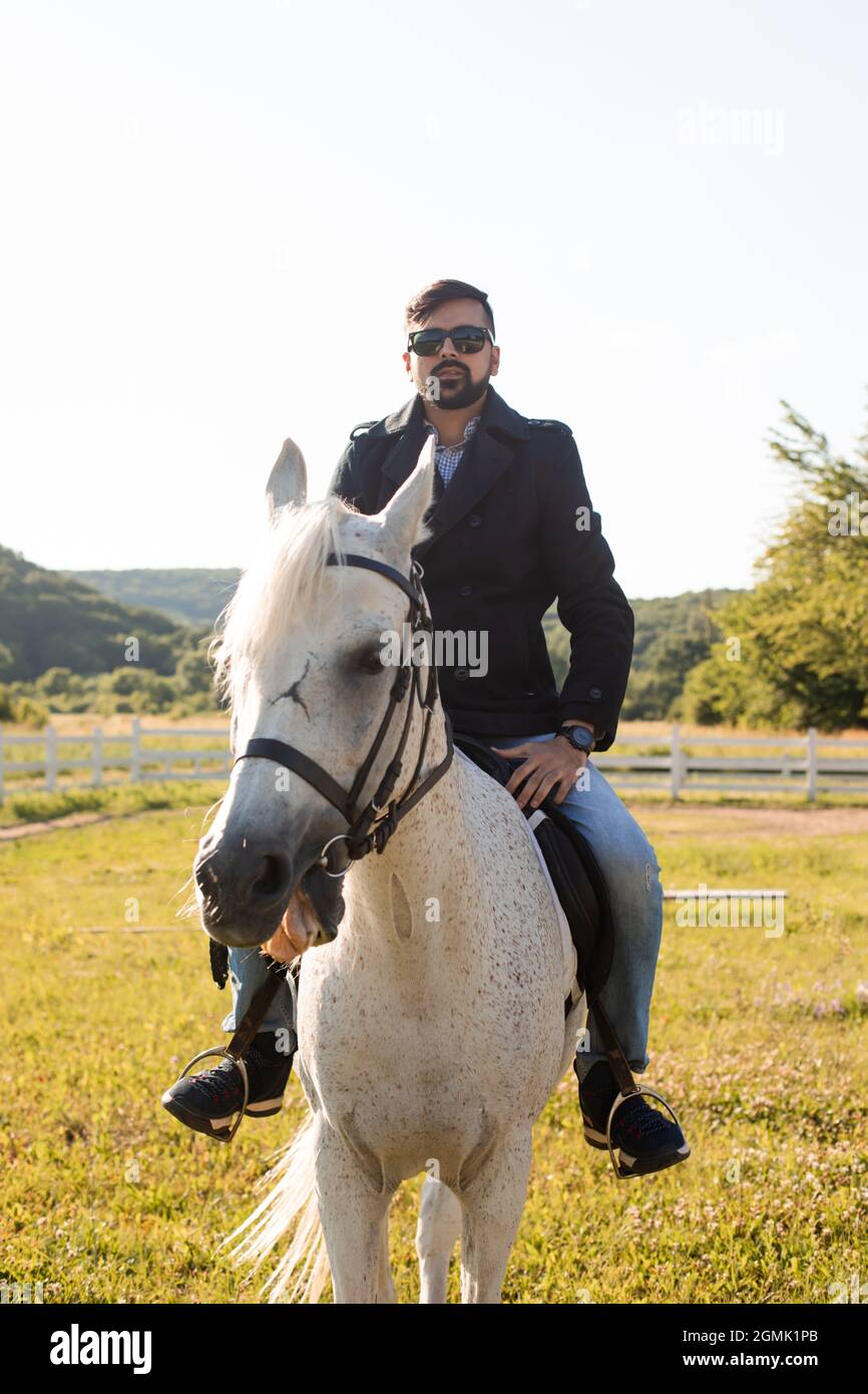 The young man is riding a horse on a farm Stock Photo - Alamy