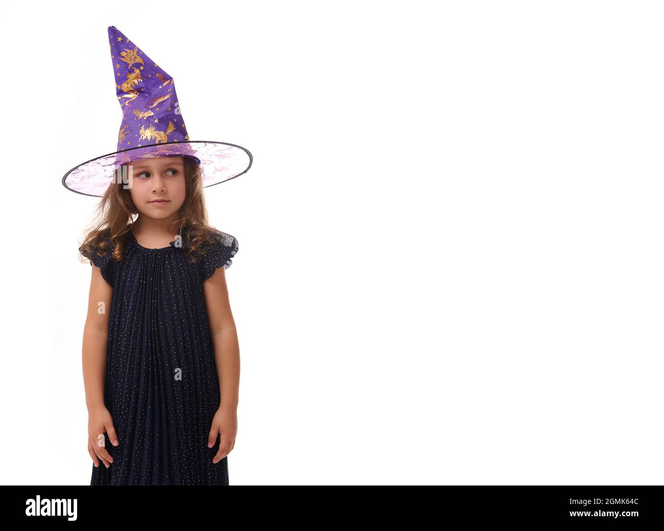 Portrait of pretty little girl wearing a wizard hat and dressed in ...
