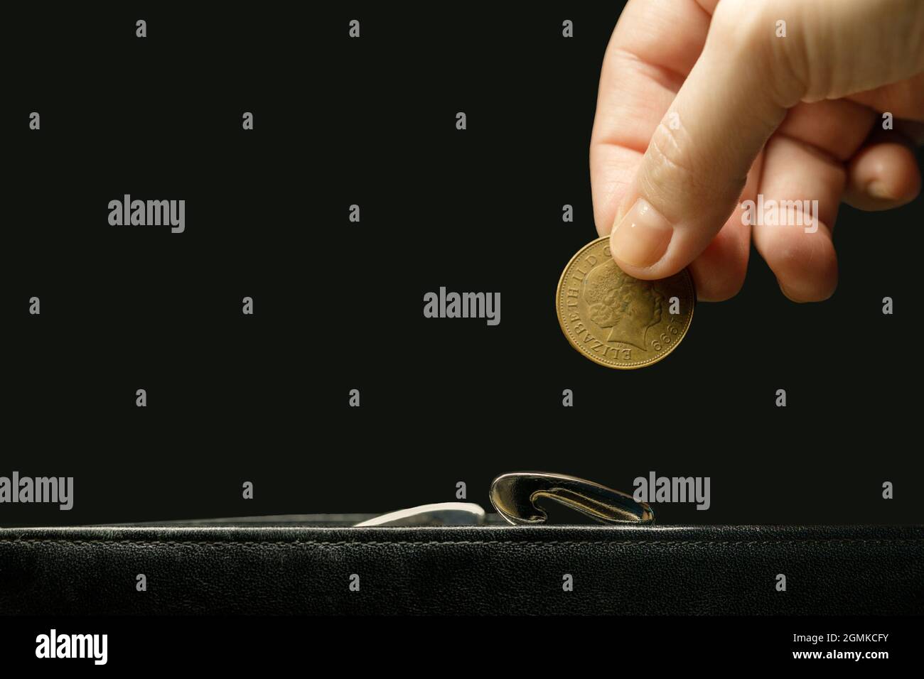 an invisible woman's hand puts a coin in a wallet Stock Photo - Alamy