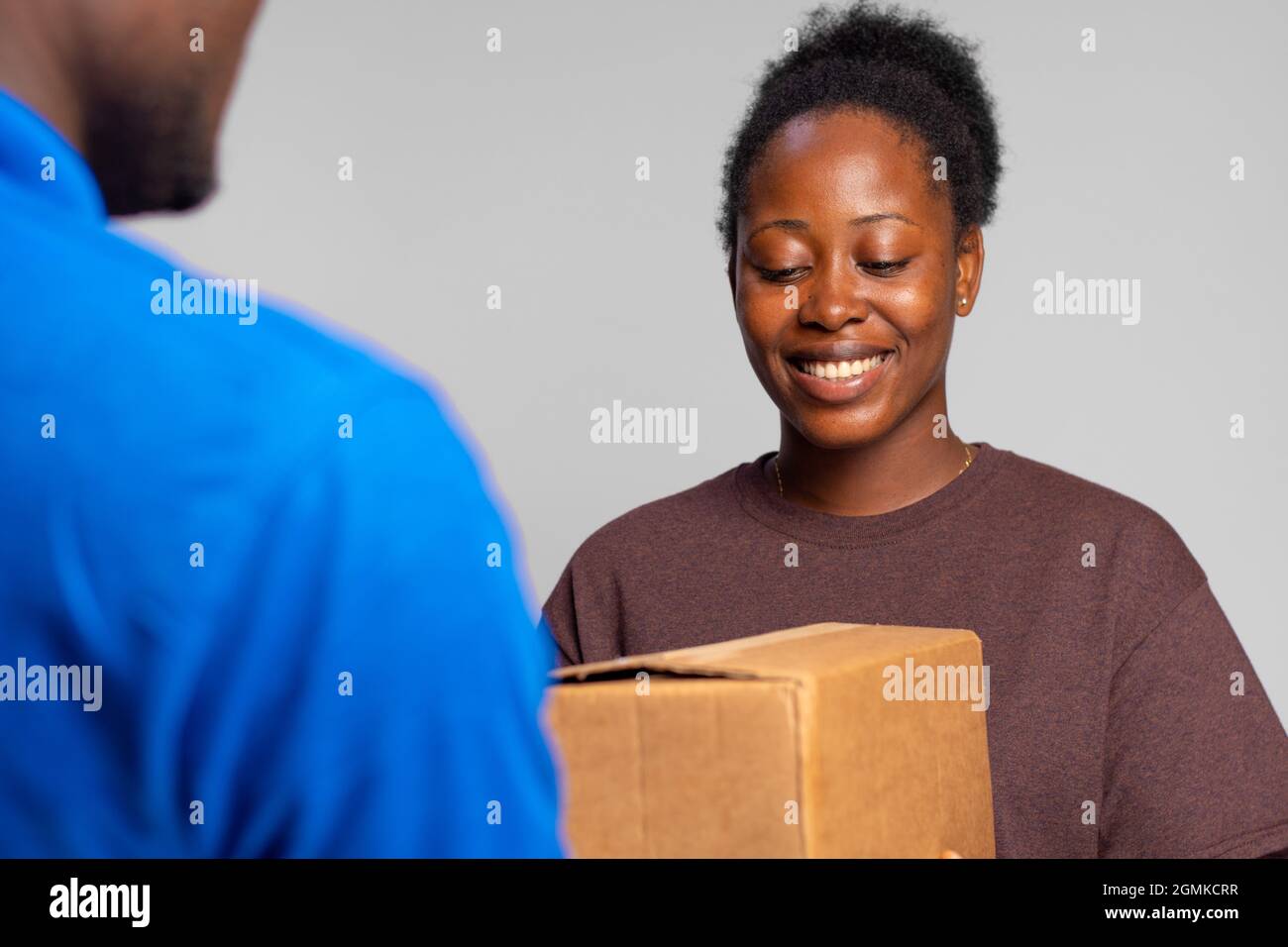 african lady receiving a package from a delivery worker Stock Photo - Alamy