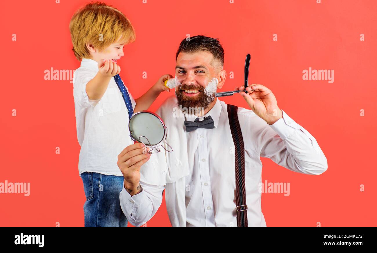 Son and father in barber shop. Shaving in barbershop. Assistant for dad ...