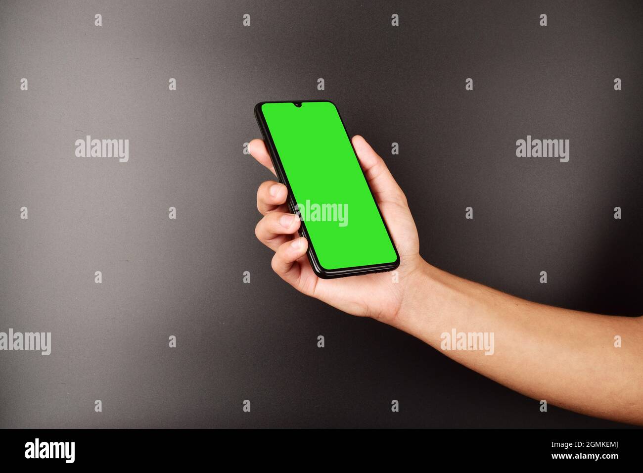 hand holding green screen smartphone over dark background Stock Photo ...