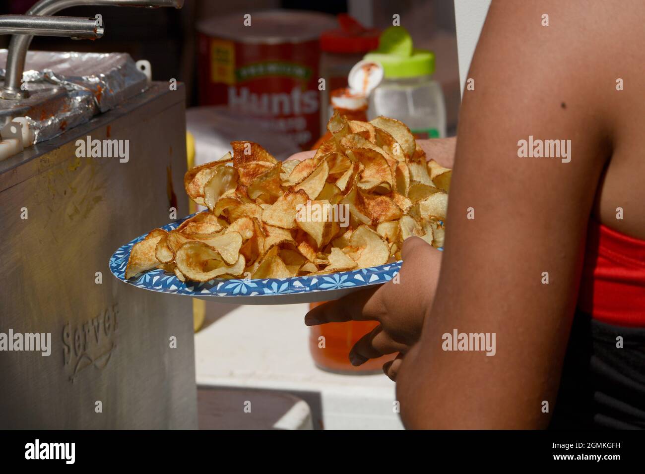 A customer adds tomato catsup to a plate of ribbon fries purchased from ...