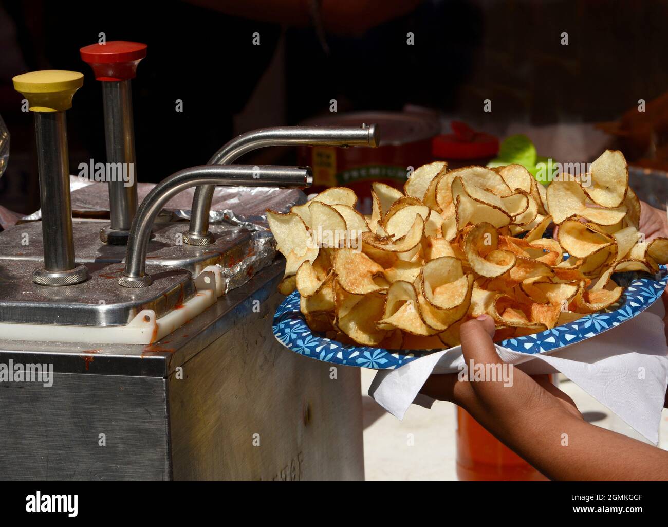A customer adds tomato catsup to a plate of ribbon fries purchased from ...