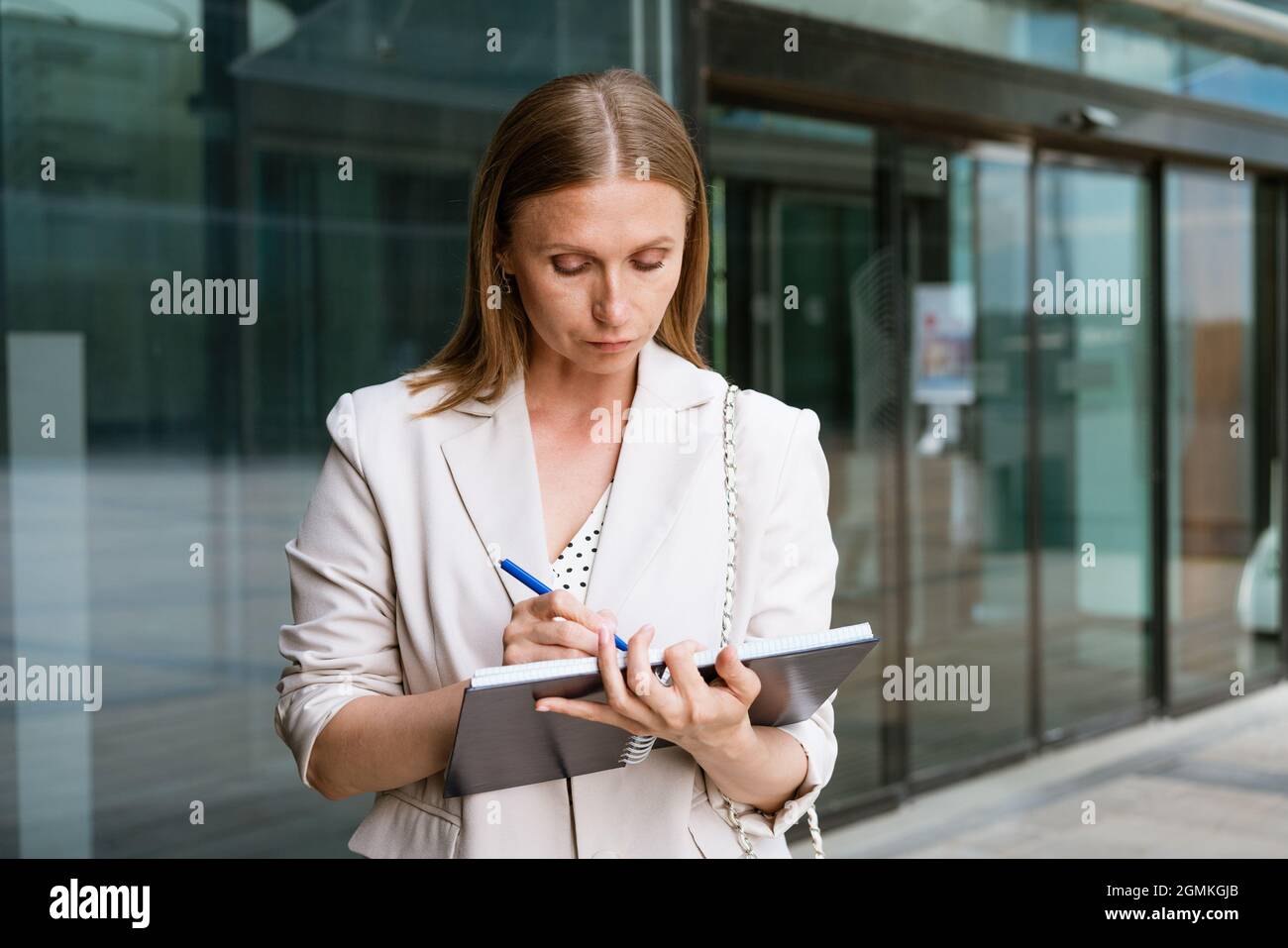 Business woman writing with pen in notebook. Caucasian successful girl ...