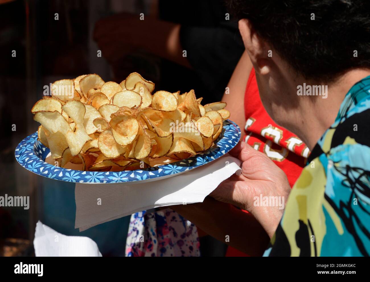 A customer purchases a plate of ribbon fries from a food vendor at the ...