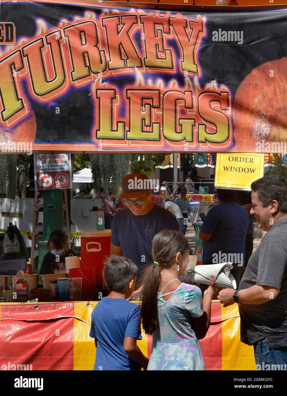 Customers purchase smoked turkey legs from a food vendor at the annual ...