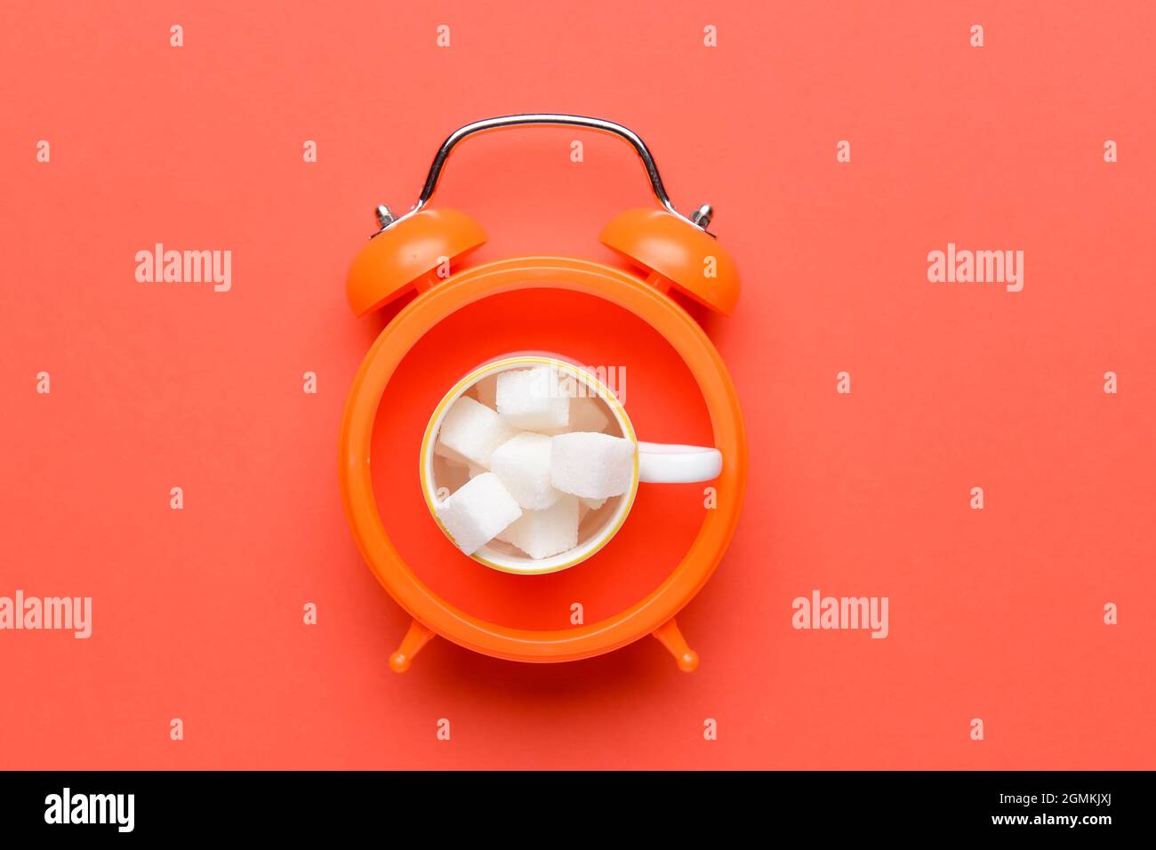 Alarm clock with sweet sugar on color background Stock Photo - Alamy