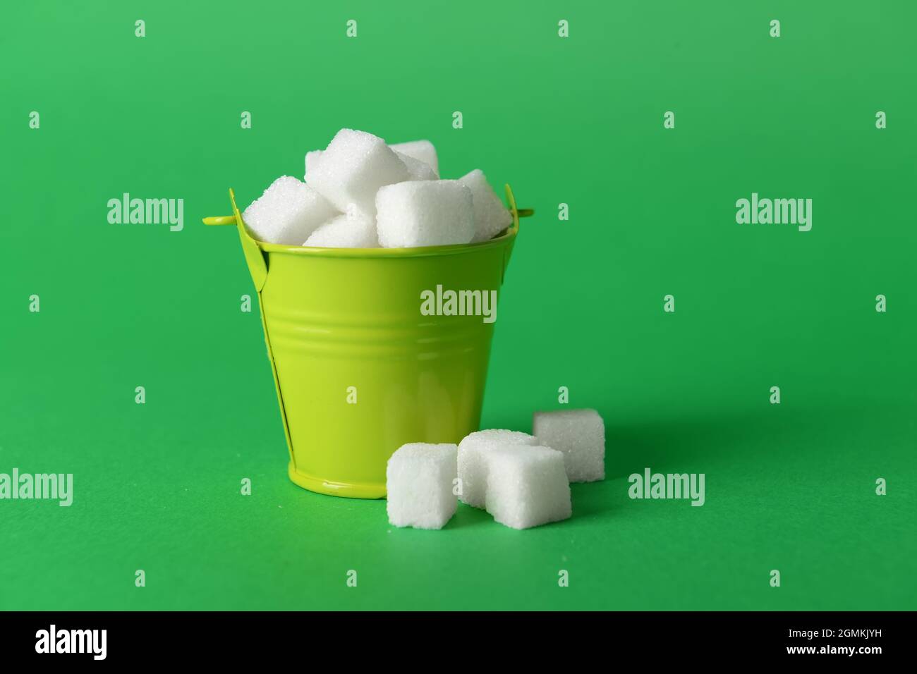 Bucket with sweet sugar on color background Stock Photo - Alamy