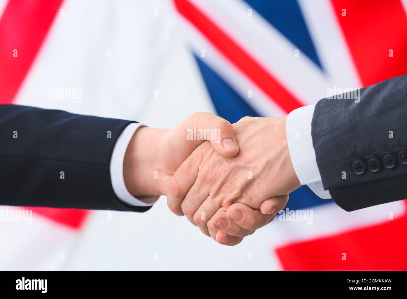 Business people handshaking against the flags of Great Britain and ...