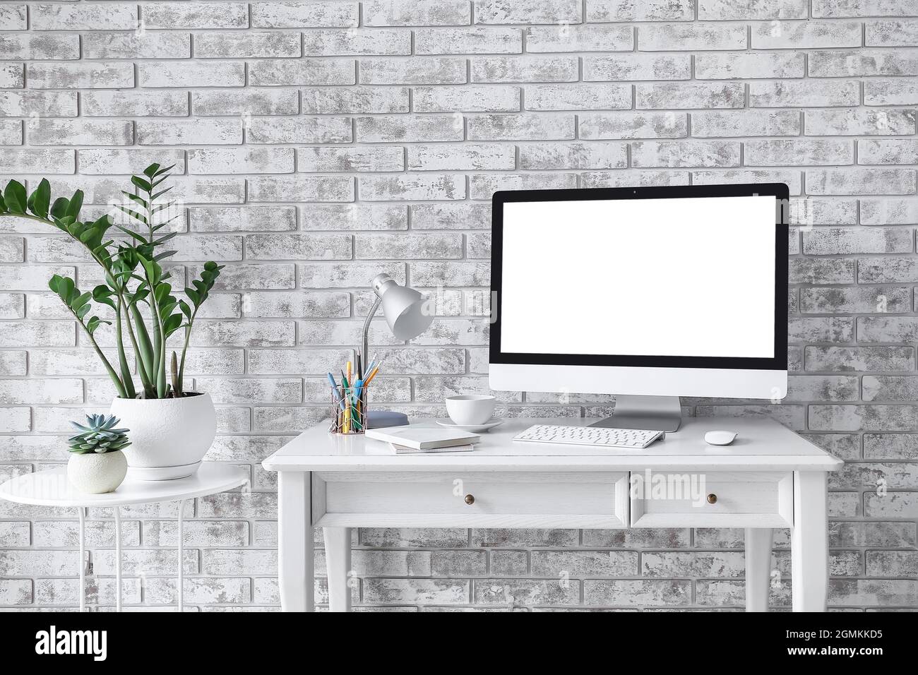 Stylish workplace with modern computer near grey brick wall Stock Photo ...