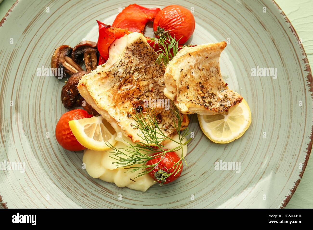 Plate with tasty baked cod fillet, vegetables and mashed potatoes on ...