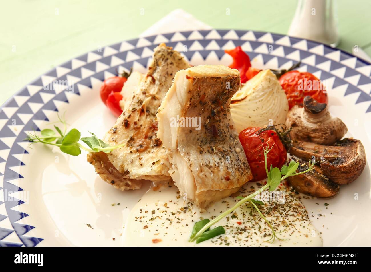 Plate with tasty baked cod fillet, vegetables and mushrooms on color ...