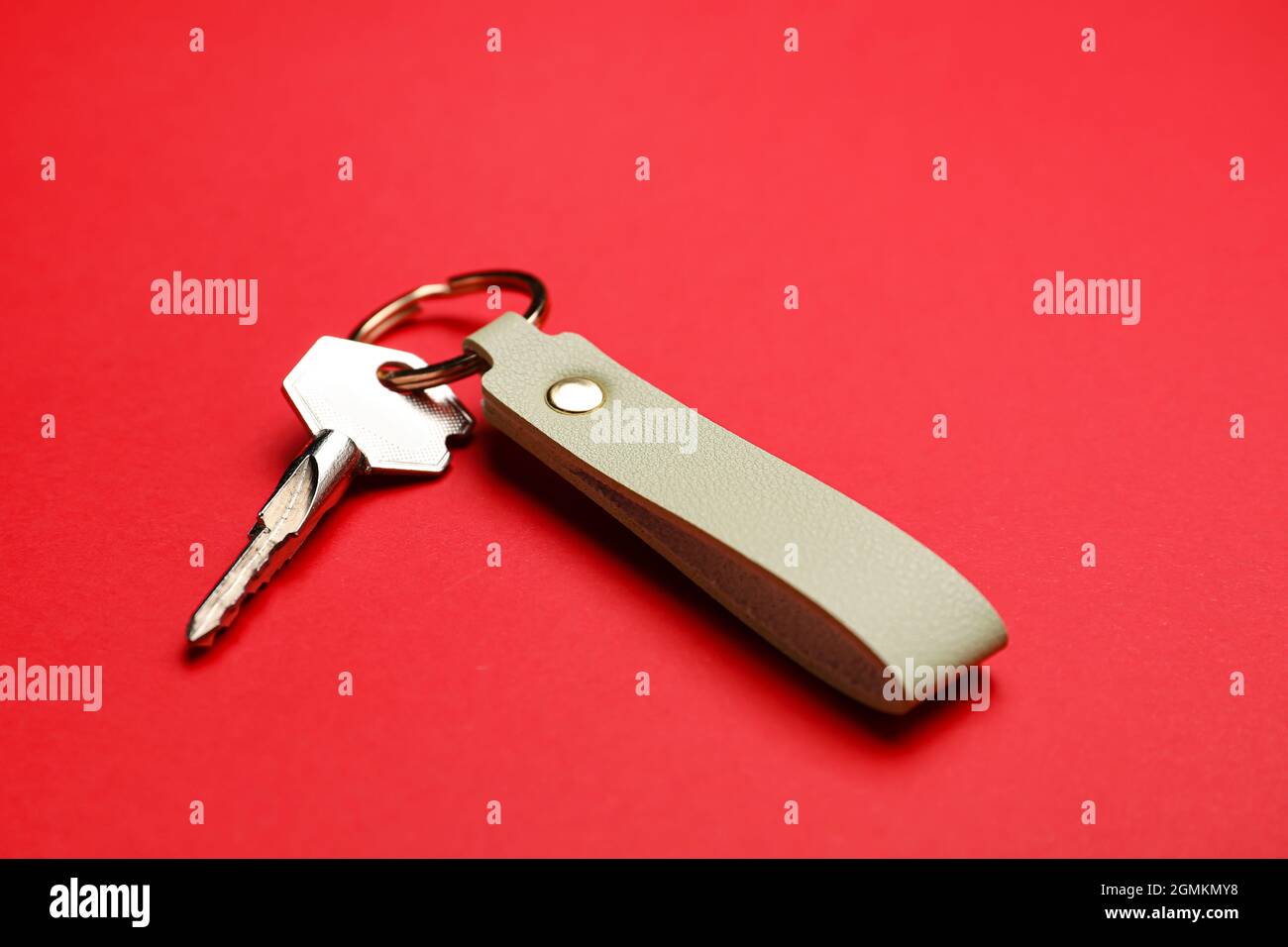 Key with leather keychain on color background Stock Photo - Alamy