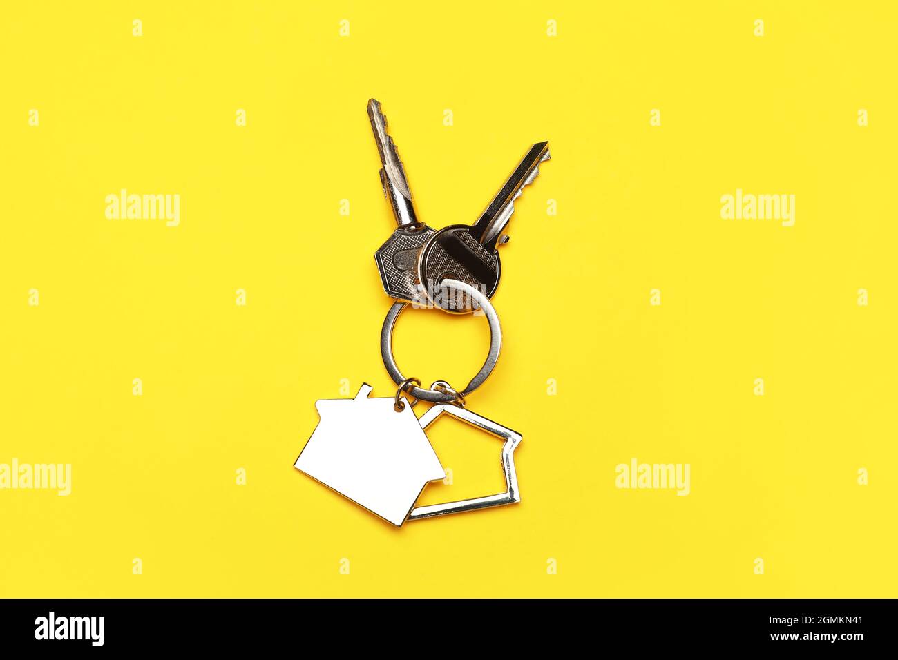 Keys with house shape keychains on color background Stock Photo - Alamy