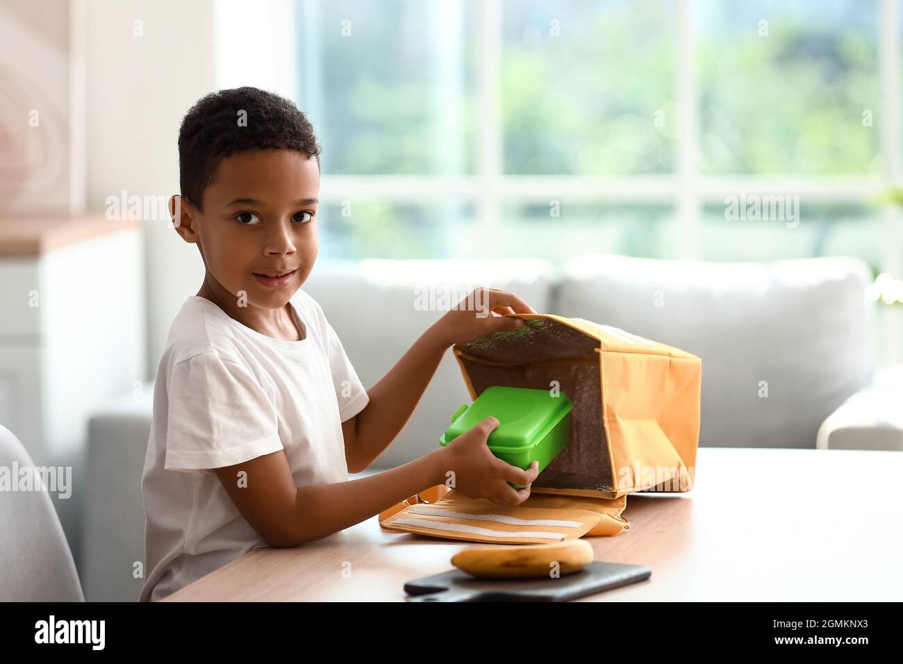 Cute little boy putting his lunch in bag Stock Photo - Alamy