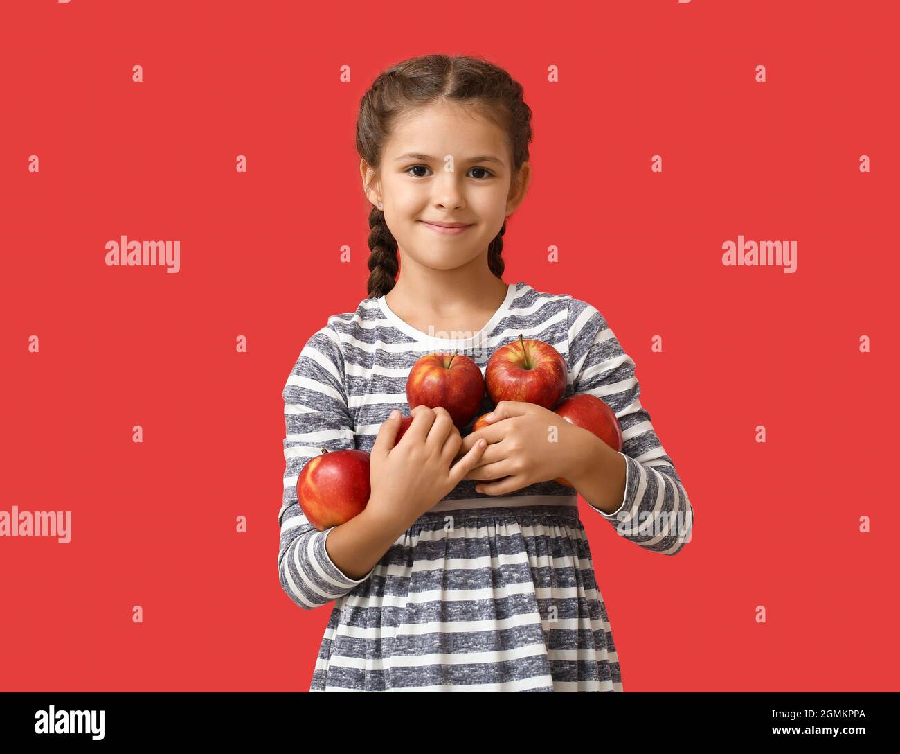 Little girl with apples on color background Stock Photo - Alamy