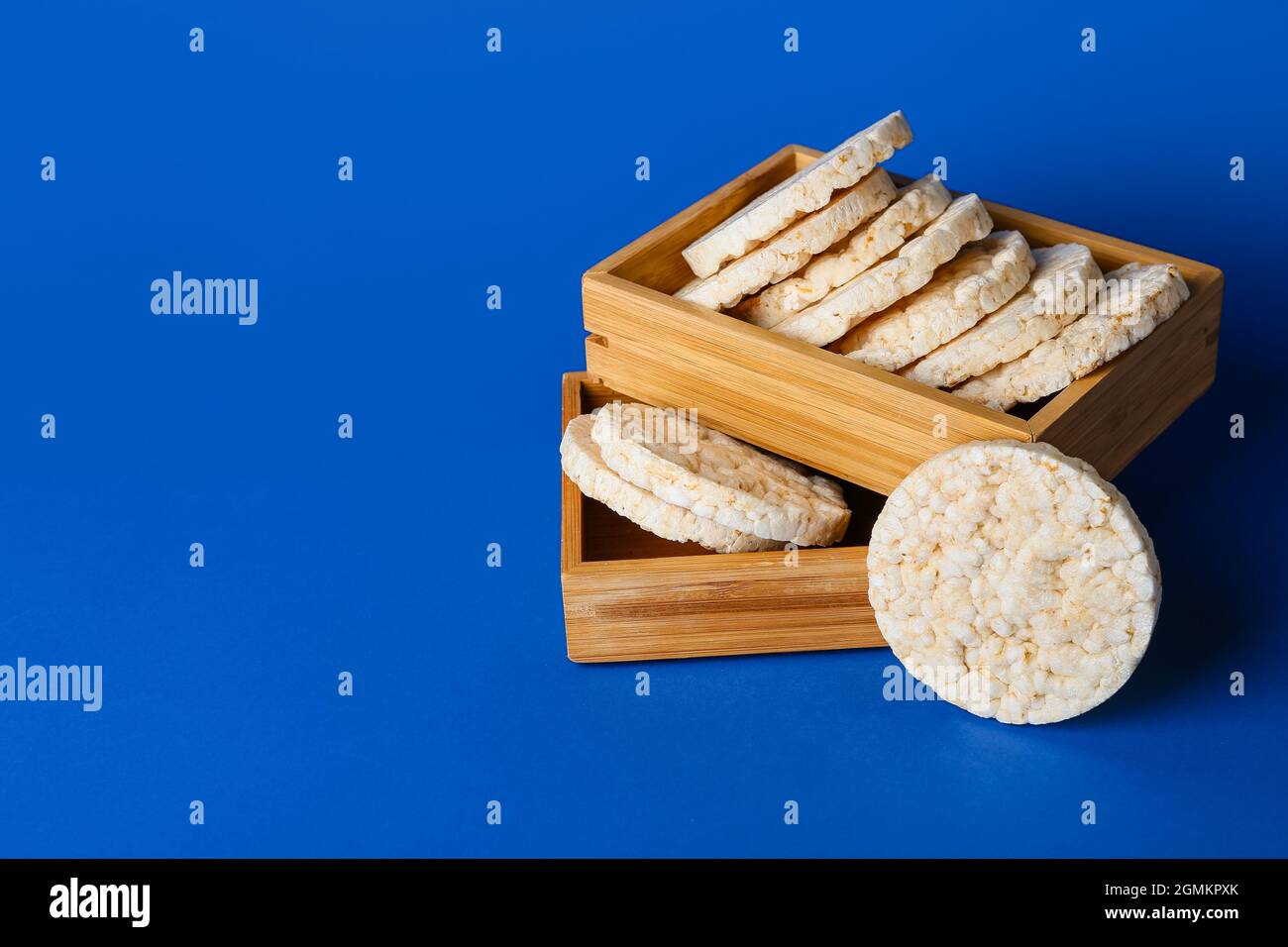 Wooden boxes with crispy rice crackers on color background Stock Photo ...