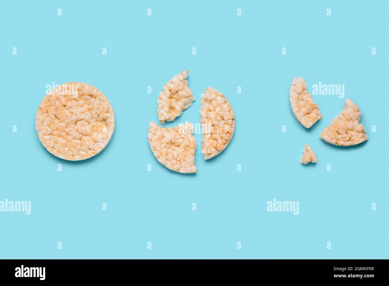 Broken puffed rice crackers on color background Stock Photo - Alamy
