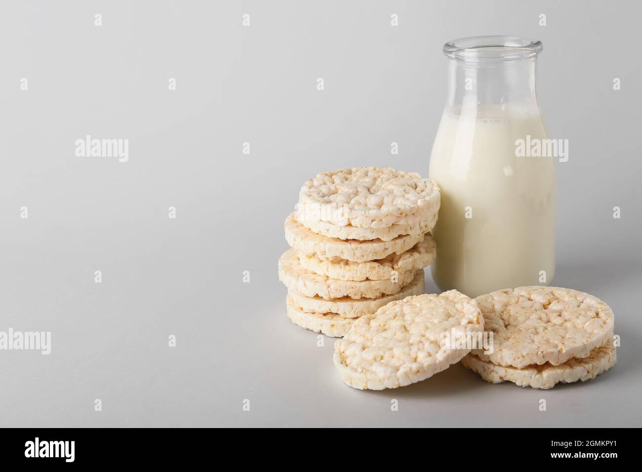 Crispy rice crackers and bottle of milk on light background Stock Photo ...