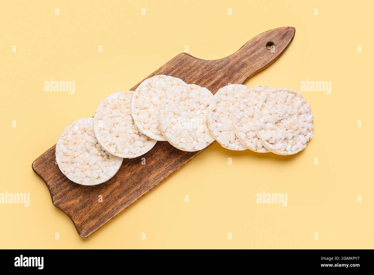 Board with puffed rice crackers on color background Stock Photo - Alamy