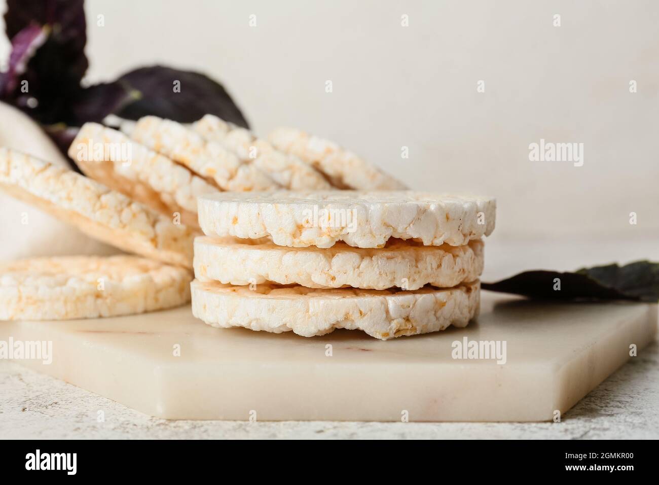 Board with puffed rice crackers on light background, closeup Stock ...