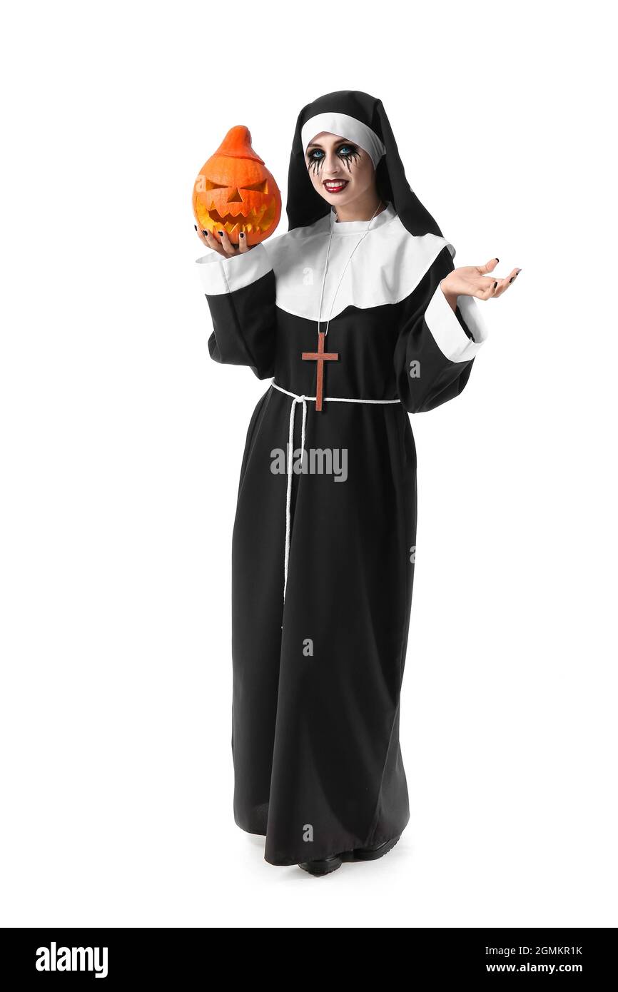 Woman dressed for Halloween as nun with pumpkin on white background ...