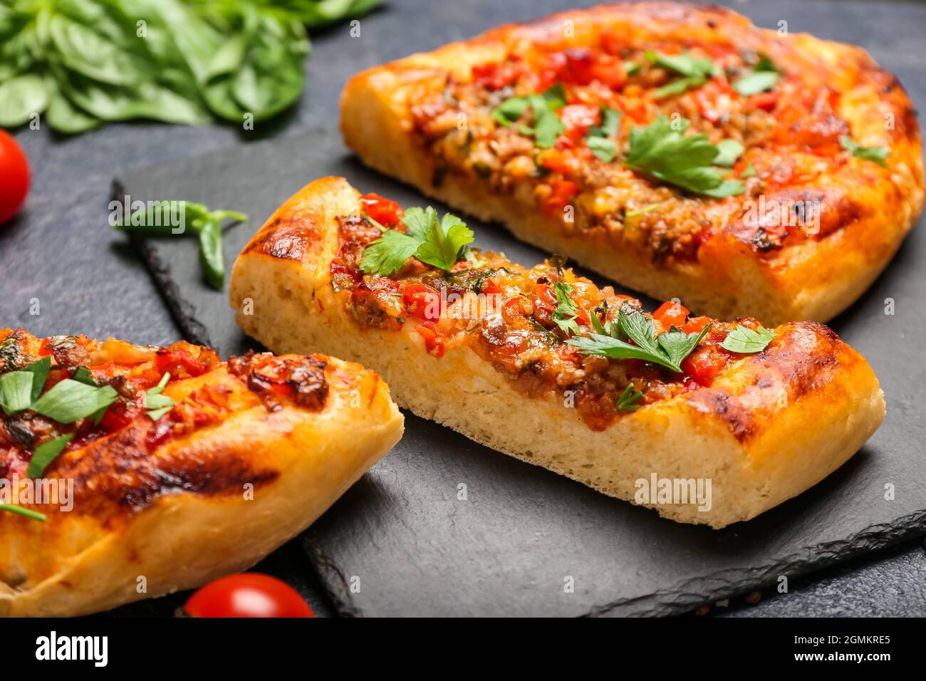 Board with sliced Turkish Pizza on black background Stock Photo - Alamy