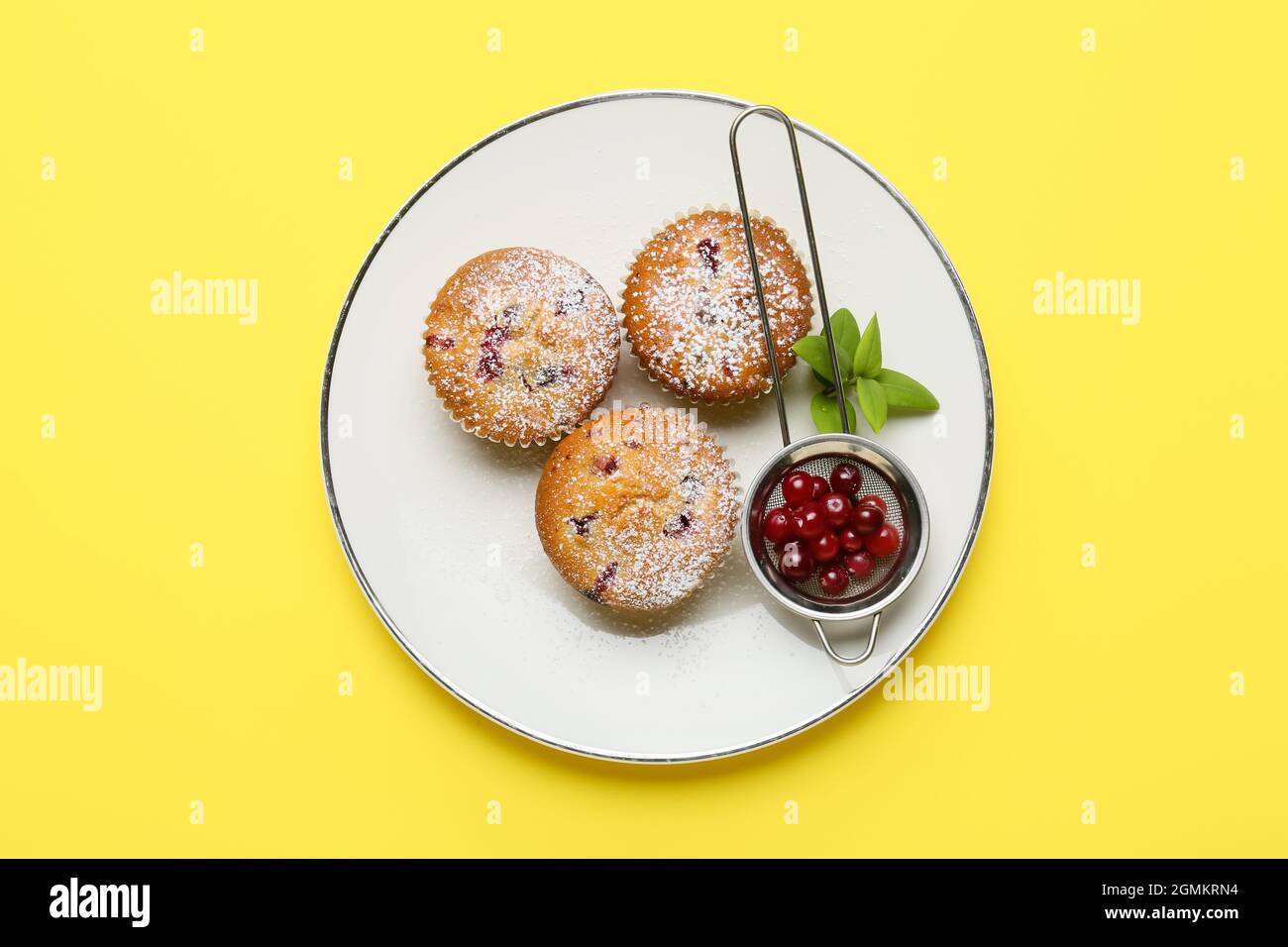 Plate with tasty cranberry muffins on color background Stock Photo - Alamy