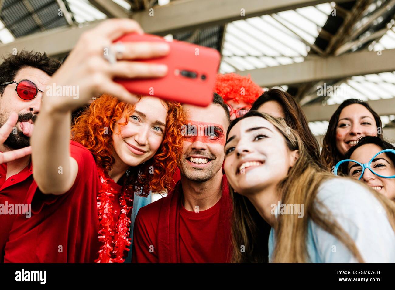 Multiethnic group of young football fans people taking selfie out of ...