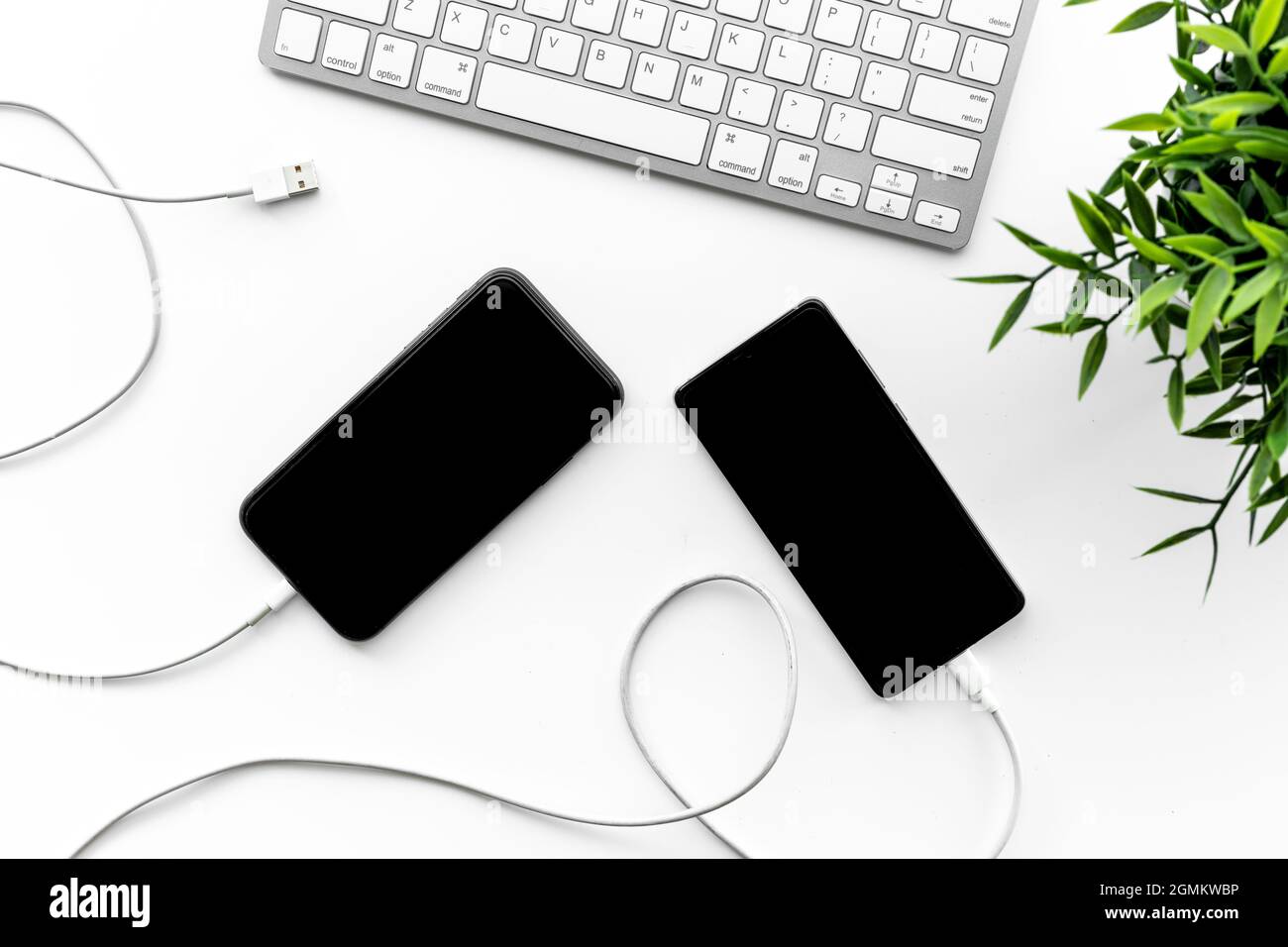 Cables for charging smartphone or laptop on office table, top view ...