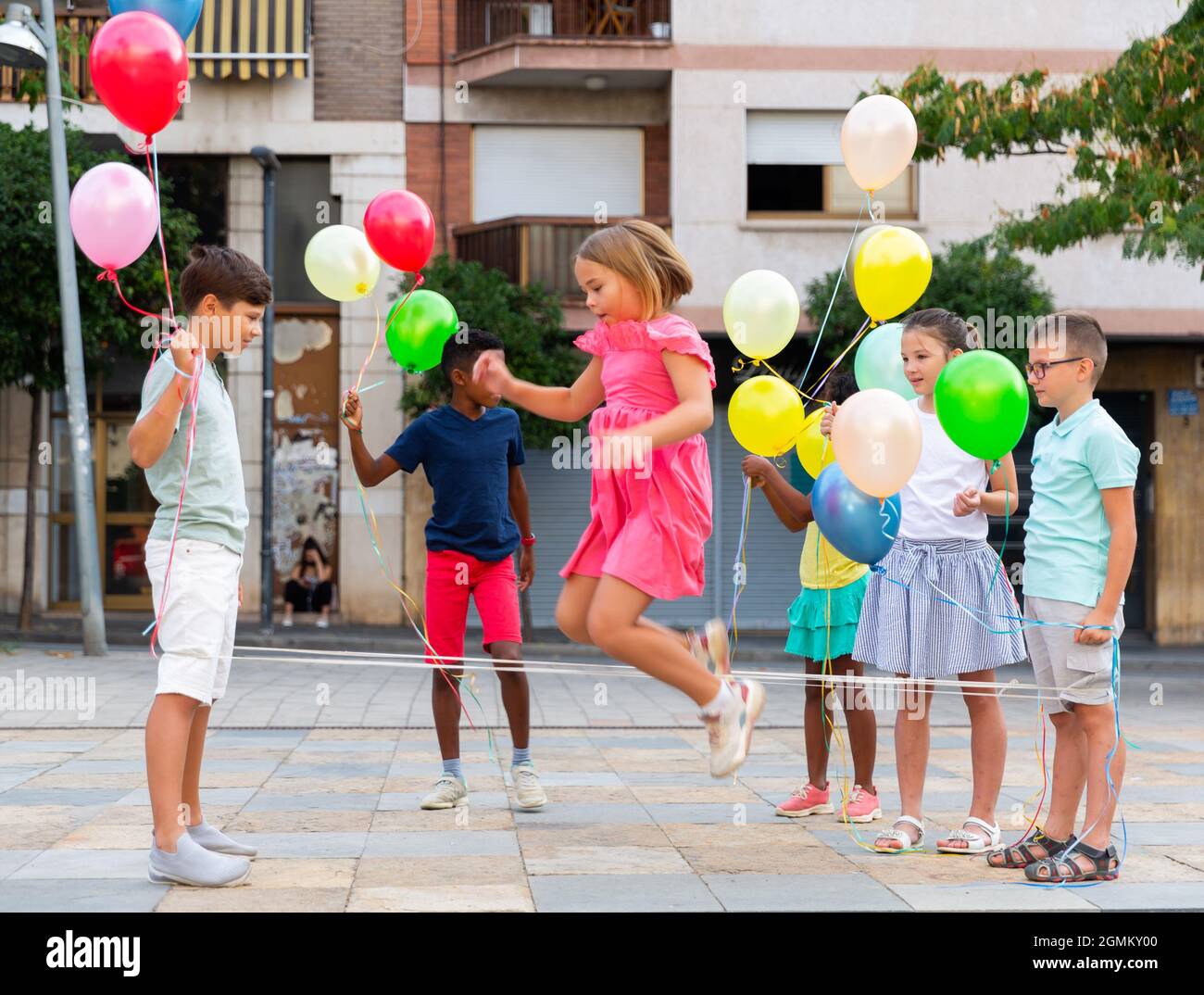 Children playing with balloons and jumping rope Stock Photo - Alamy