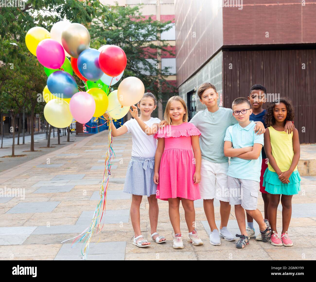 Full length portrait of happy tweens with balloons on city street Stock ...