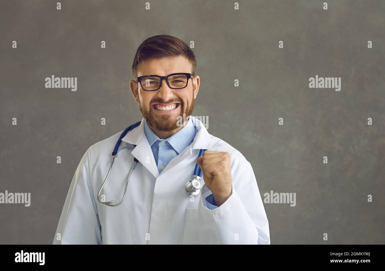Happy young male doctor smiling and fist pumping celebrating his ...