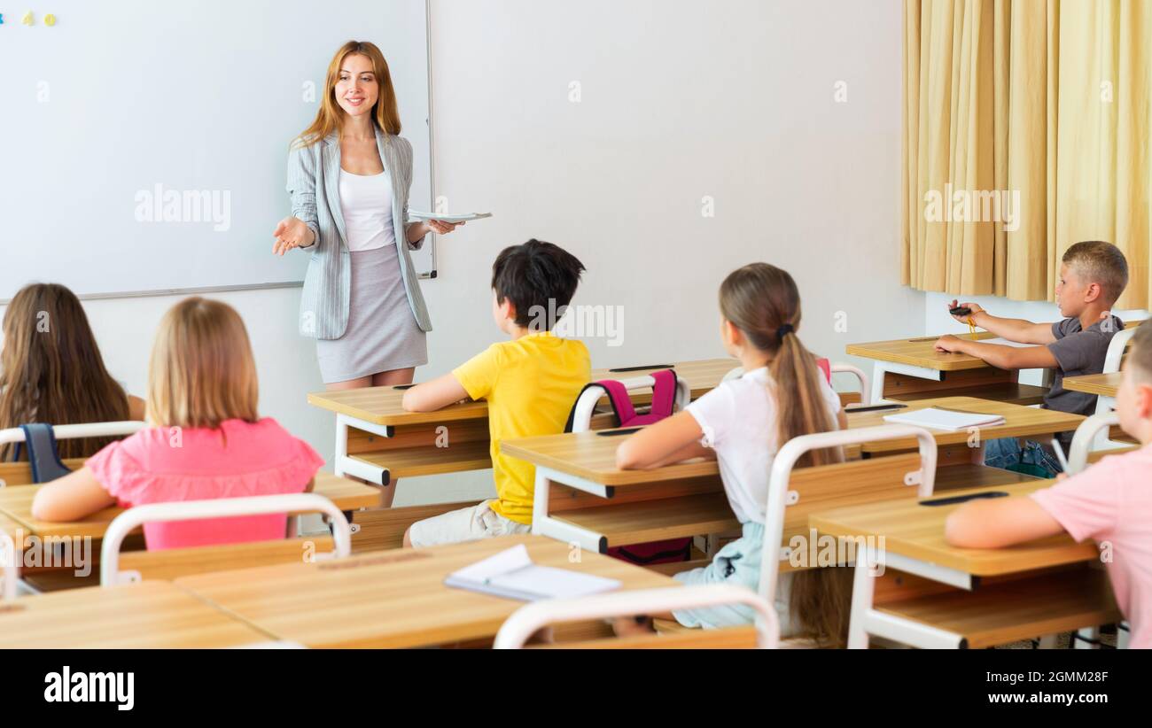 Schoolchildren listening to teacher Stock Photo - Alamy