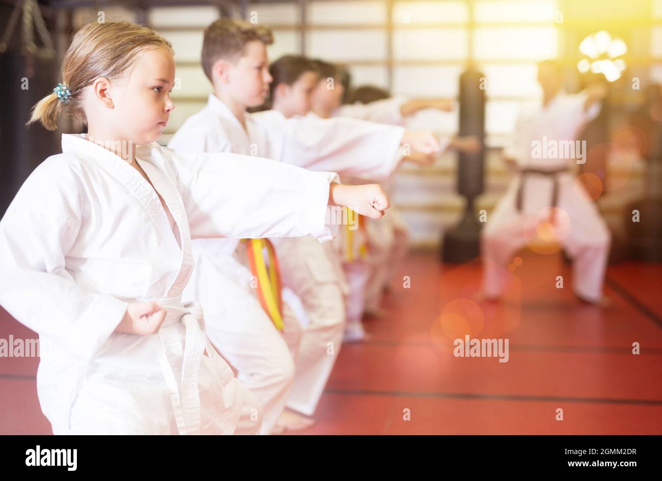 Kids in kimonos practicing karate techniques in group workout at ...