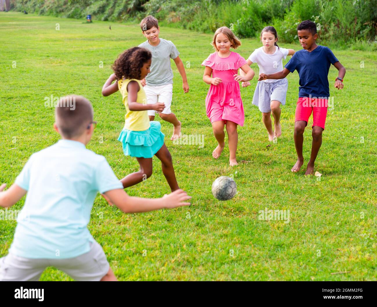 Boys and girls playing football outdoors Stock Photo - Alamy