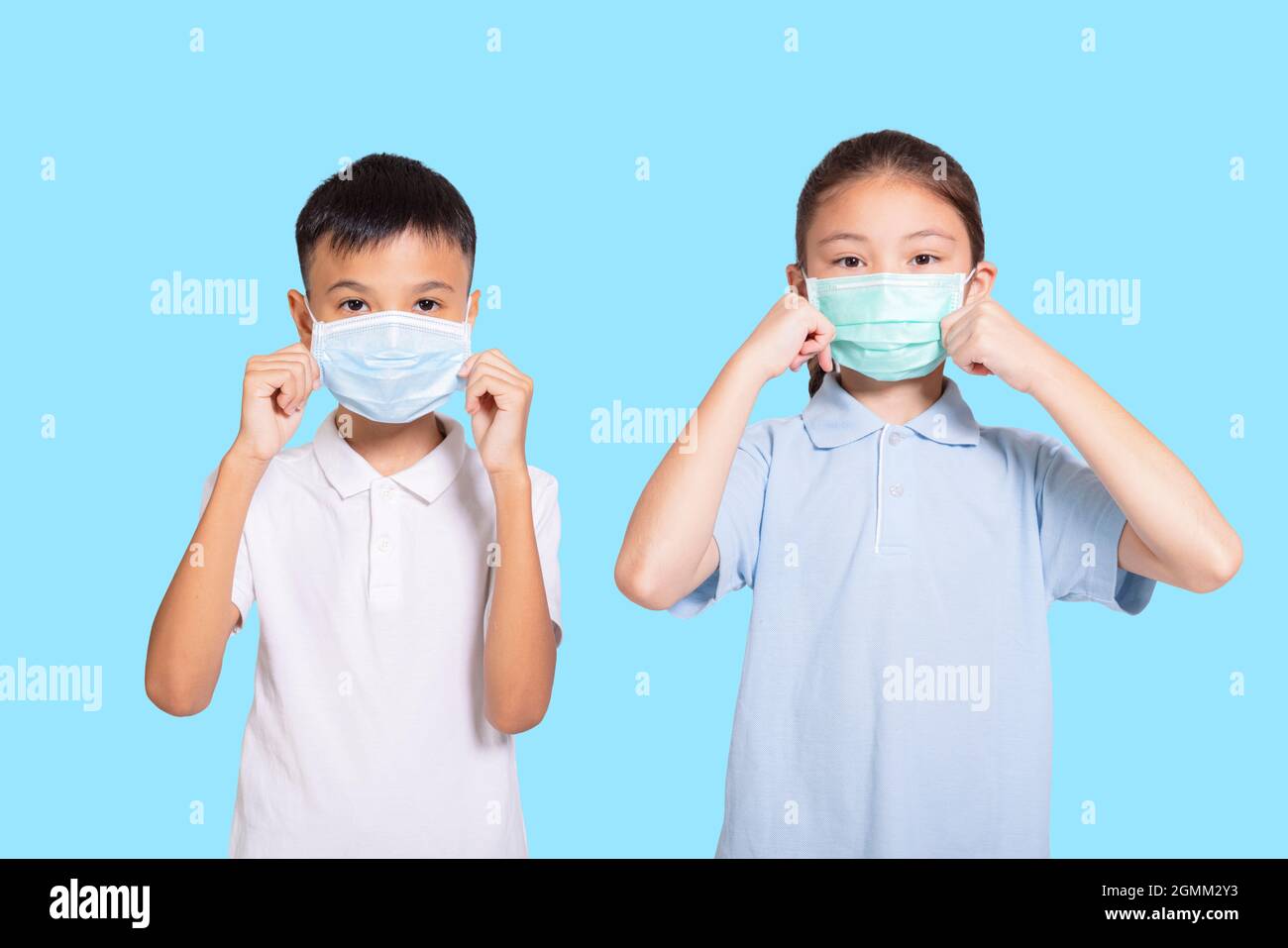 Boy and girl in medical mask. Isolated on blue background Stock Photo ...