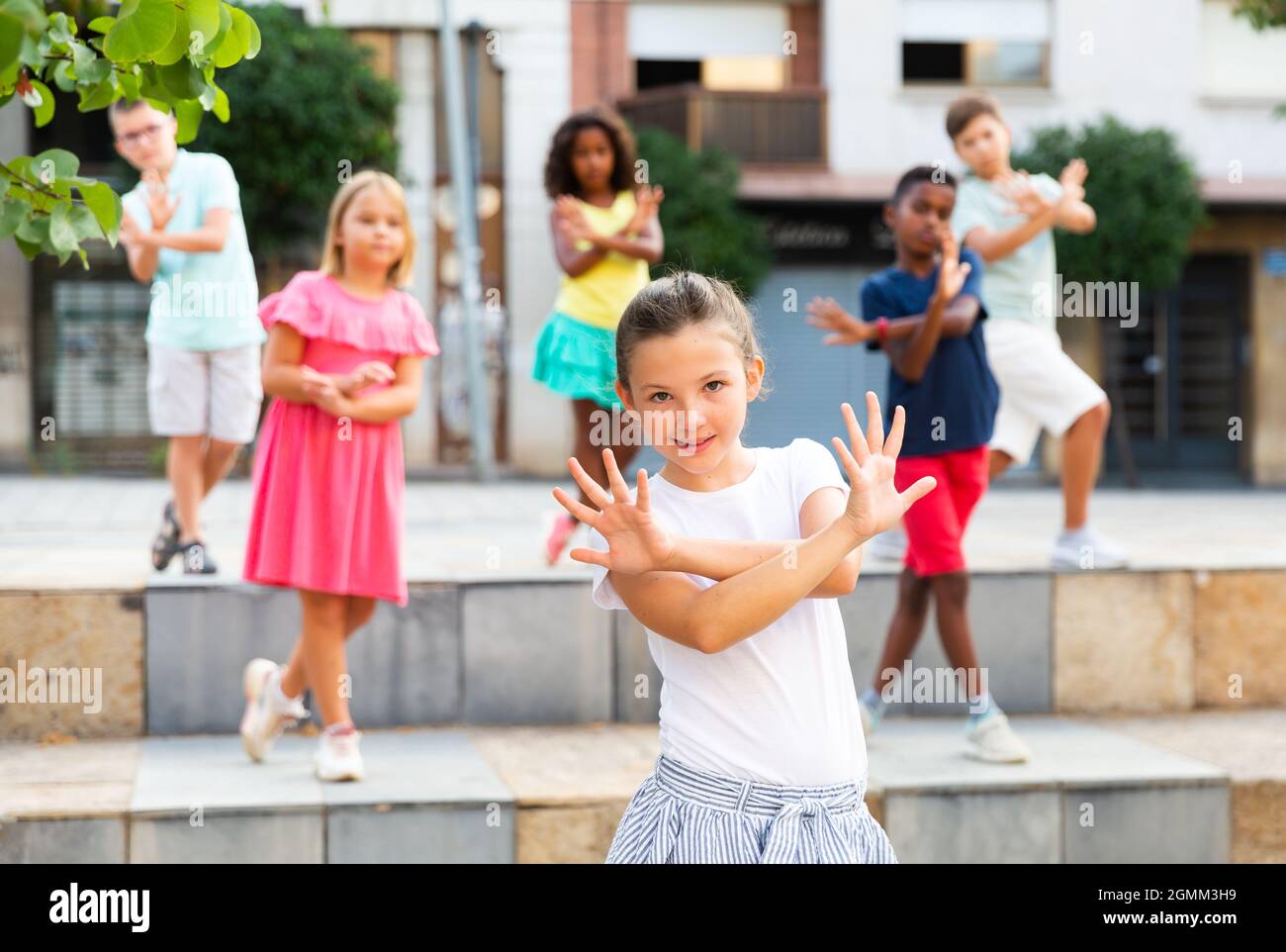 Smiling tween girl street dancer posing during performance with group ...